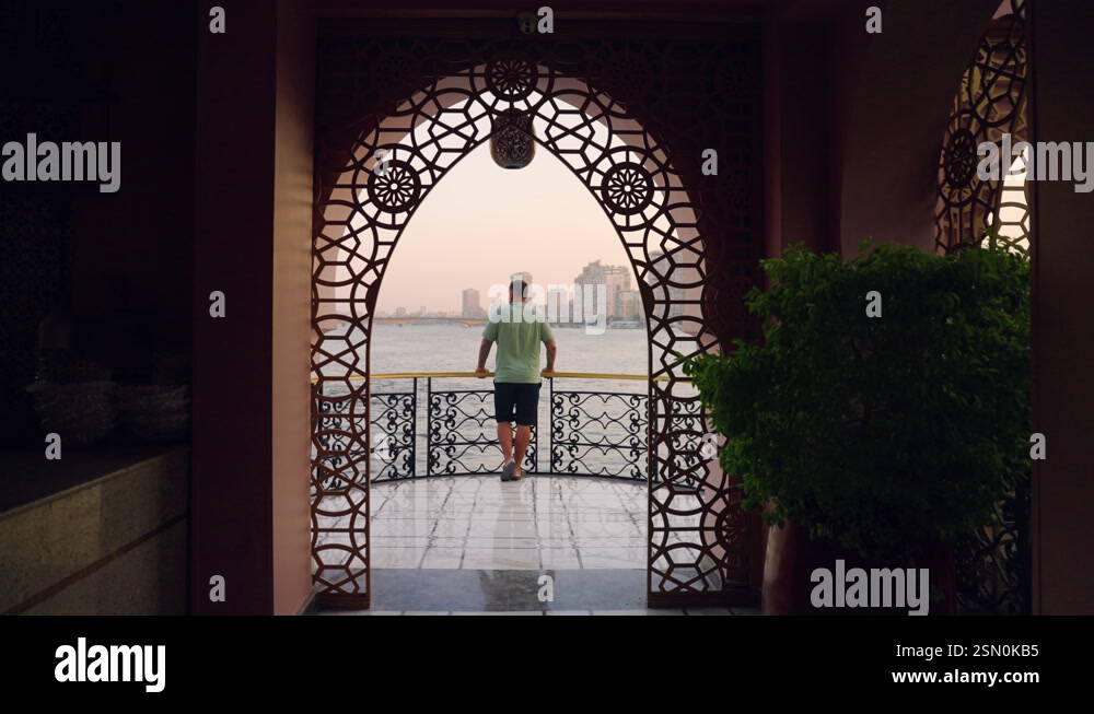 Back View Of Man Walking Towards Balcony Of Hotel Overlooking Nile ...