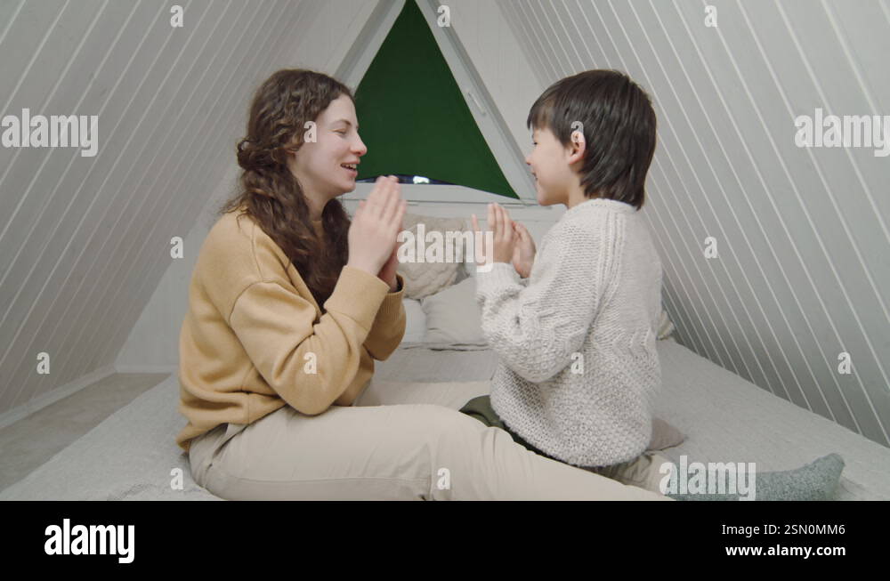 Young Mom and Son Playing Clapping Game on Bed in Attic Stock Video ...