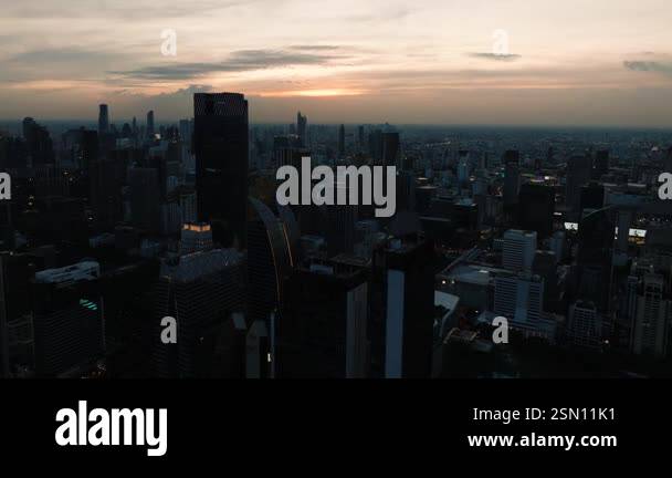 Dusk over Bangkok city with tall buildings creating a dense and ...