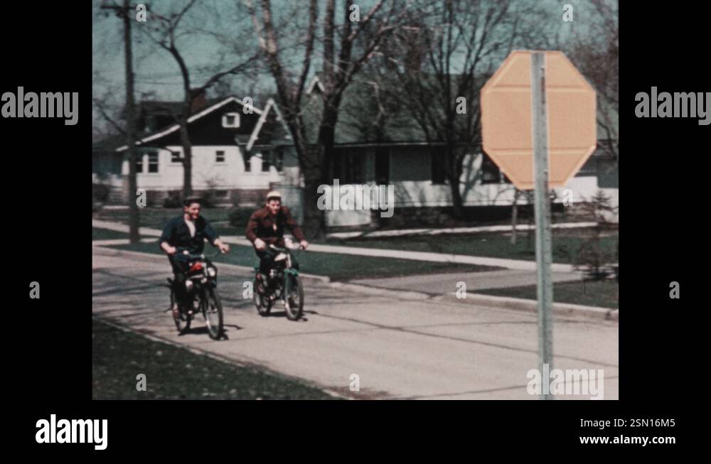 1950s: Boys ride motorbikes down street and stop at stop sign. Boys ...