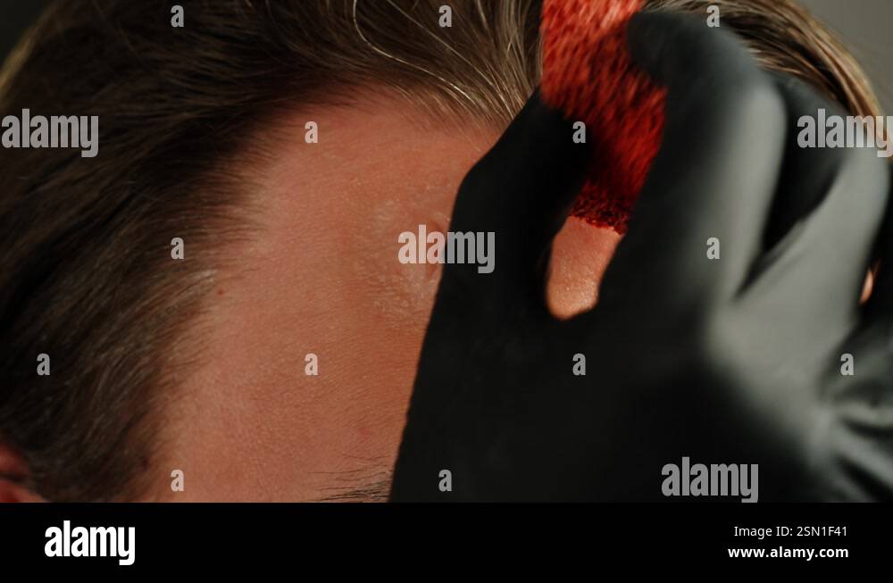 Make up artist making scars and bullet shot forehead headshot with fake ...