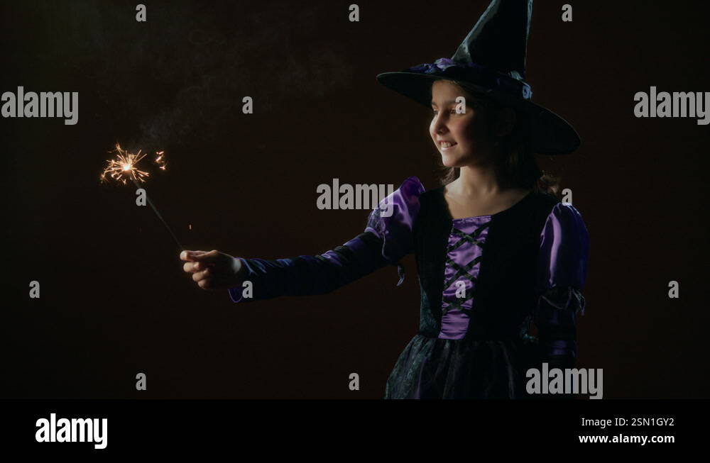 Girl in Witch Costume Waving Burning Sparkler in Dark Black Room Stock ...