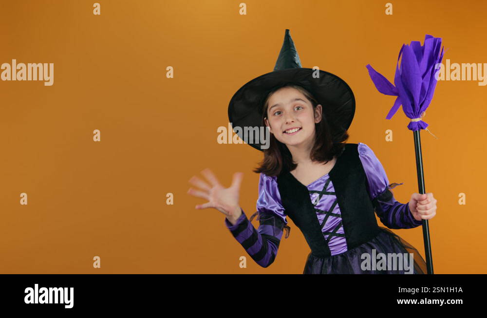 Cheerful Young Witch with Broom Appearing from Corner and Waving on ...