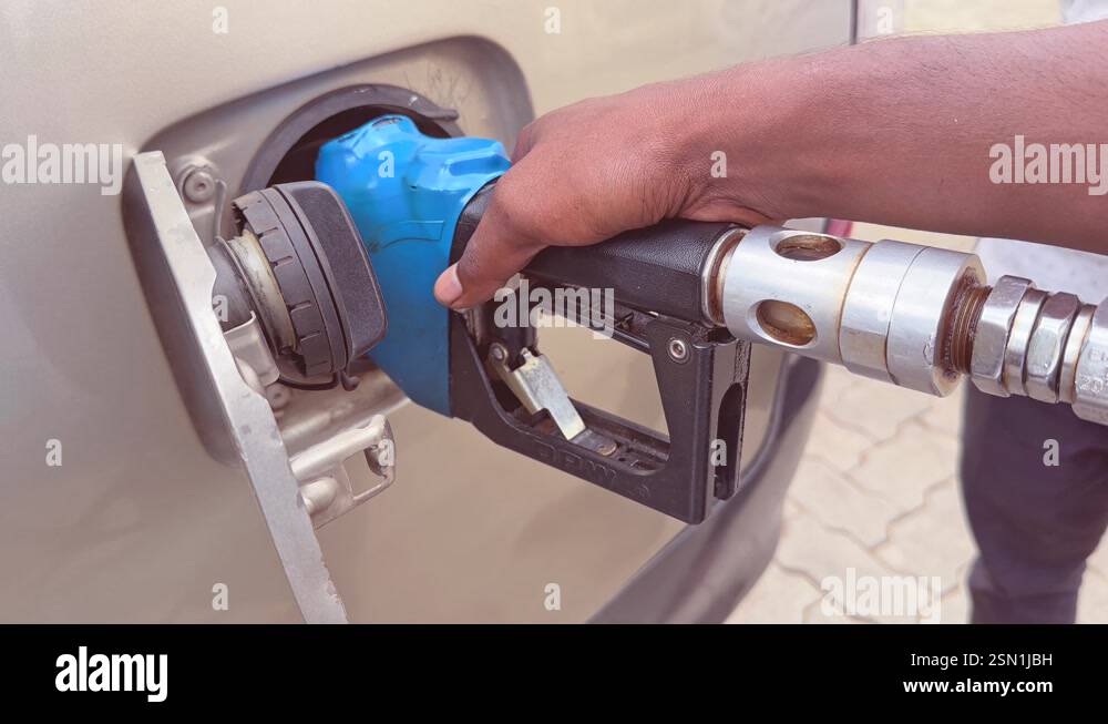 Closeup of hand filling a fuel into the car at indian filling station ...