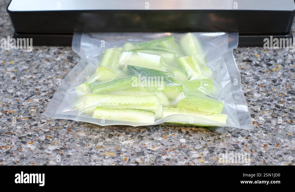 Process of packing cucumbers in bag using vacuum machine on a gray ...