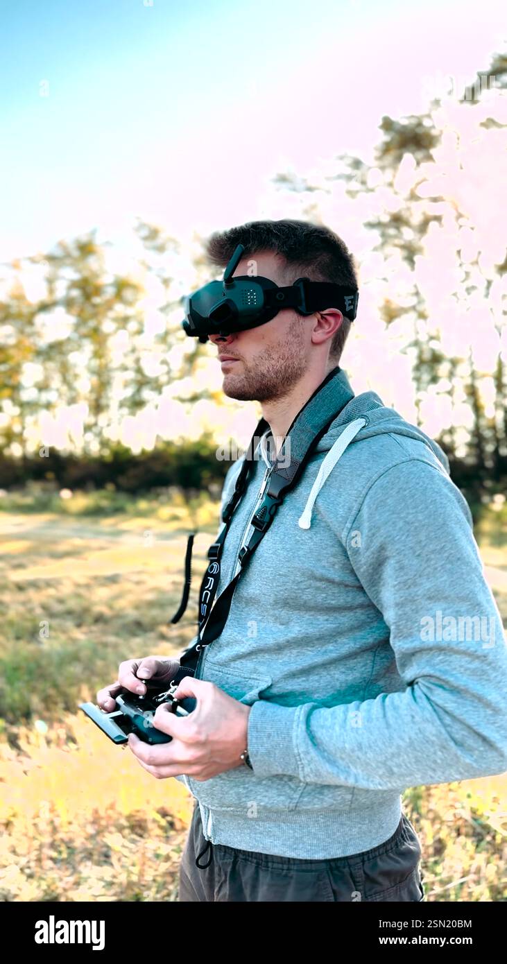 FPV copter pilot controls the drone using a remote control and wearing ...