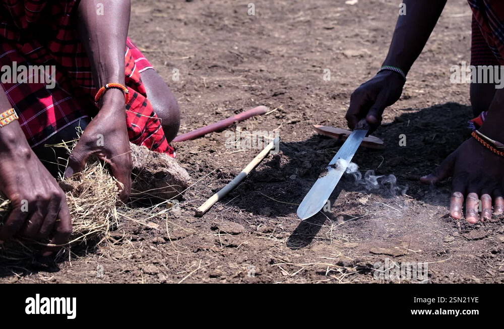 Making Fire: Close-up of Maasai hands creating fire with a stick and ...