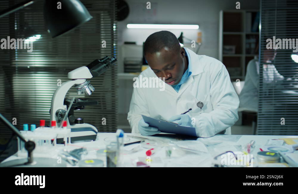 African American Forensic Scientist Examining Evidence and Talking ...