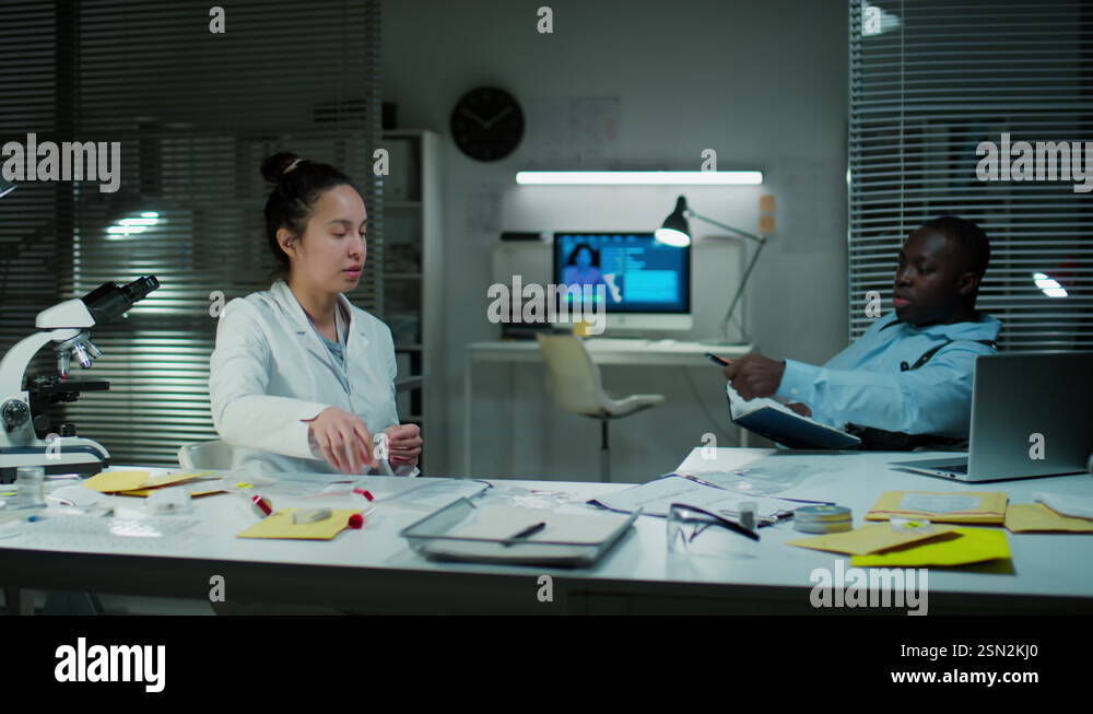 Forensic Scientist Describing Evidence to Police Officer in Crime Lab ...