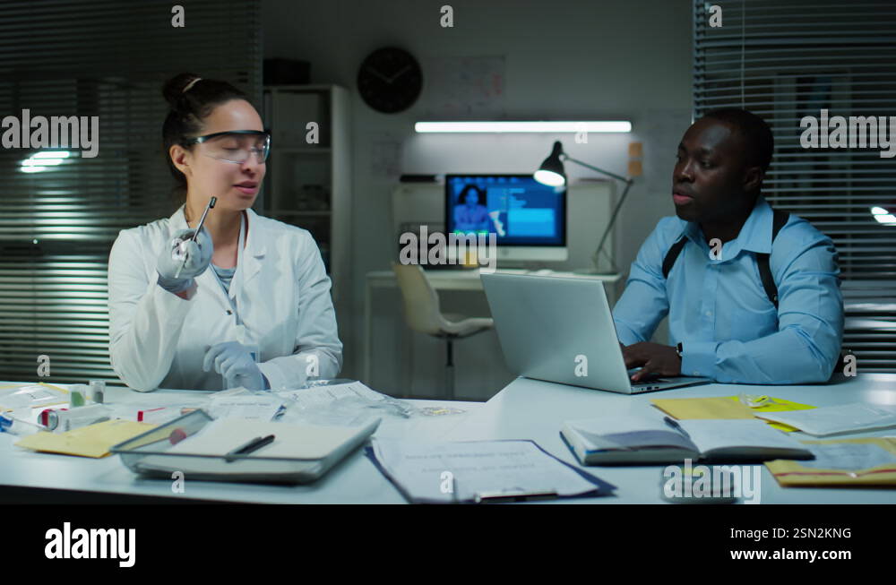 Forensic Scientist Describing Evidence as Police Officer Typing on ...