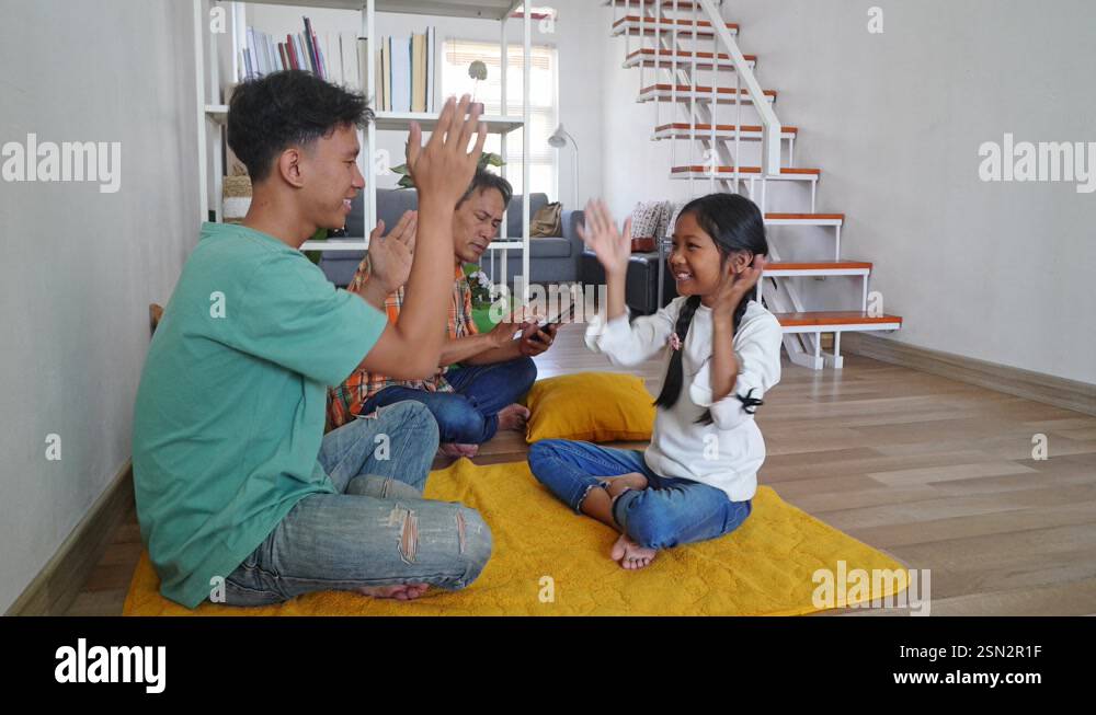 Brother And Little Sister Playing Clapping Hands While Father Using ...