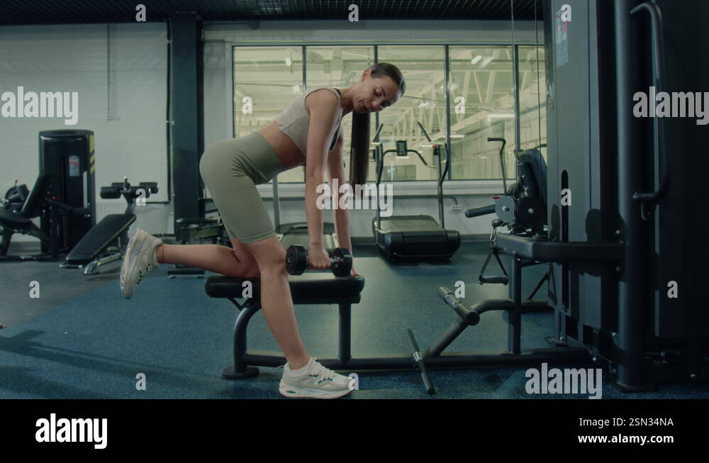 Woman Doing Dumbbell Bent-Over Rows on Bench in Modern Gym Stock Video ...