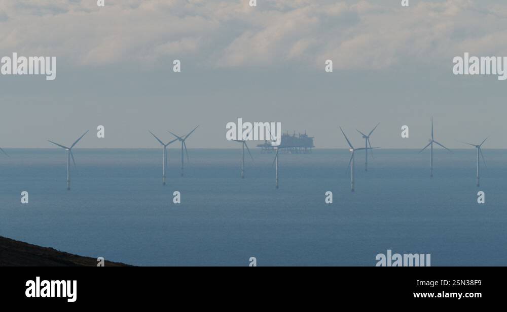 A gas platform and offshore windfarm in Morecambe Bay from moorland ...