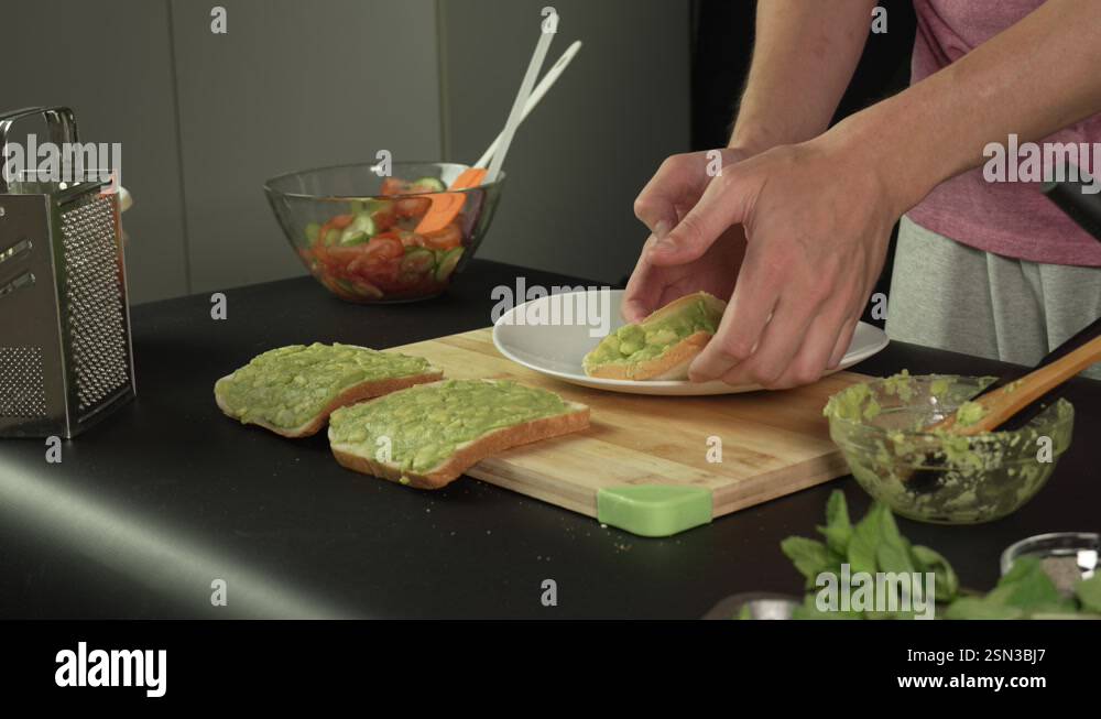 Hands of middle man european putting toasts with guacamole on a plate ...
