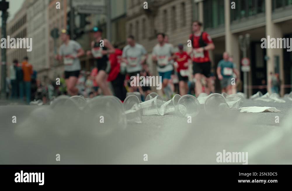 Marathon runners passing water station amidst discarded cups Stock ...