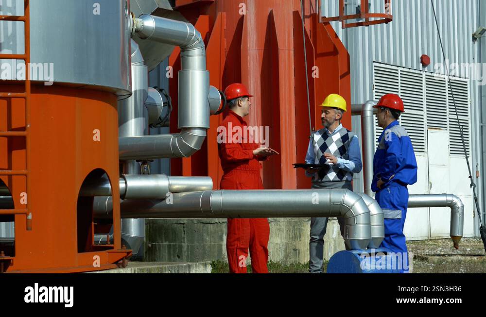 Two Oil Refinery Workers and Production Manager Meeting in front of ...