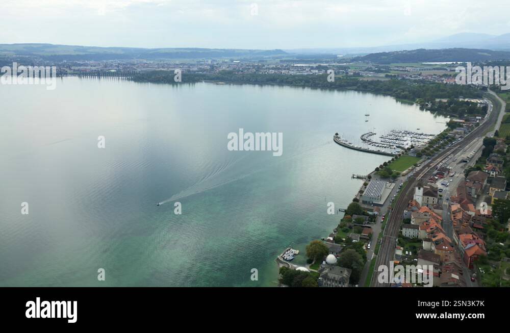 Pan drone shot of Lake Neuchatel with Yverdon-les-Bains in the back in ...