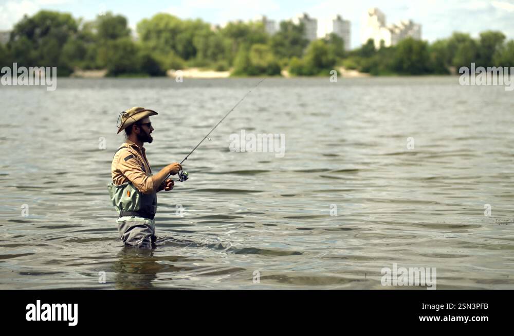 Fisherman With Rod Tackles. Fisher In Waders. Angler Catching Fish ...