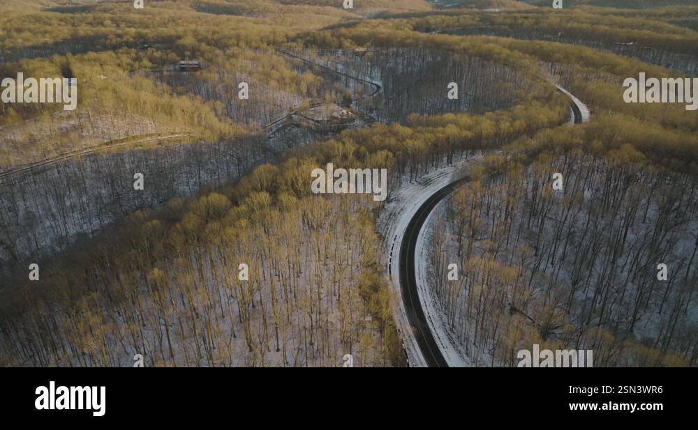 Natchez Trace Scenic Highway winding through forest of sunlit deciduous ...