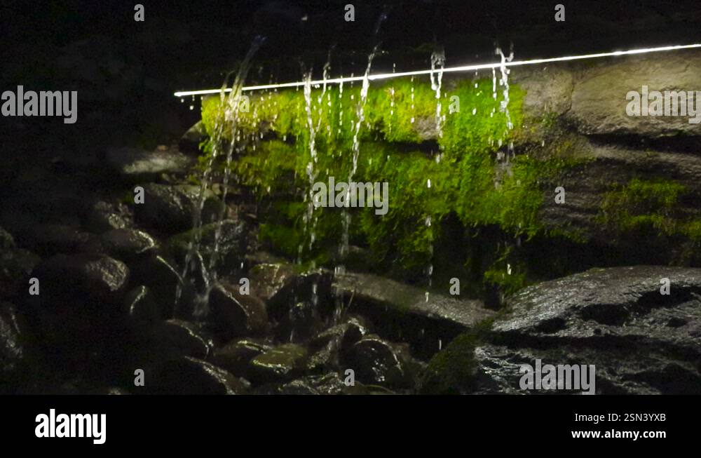 Footage of a small water stream of a waterfall, water is dripping over ...