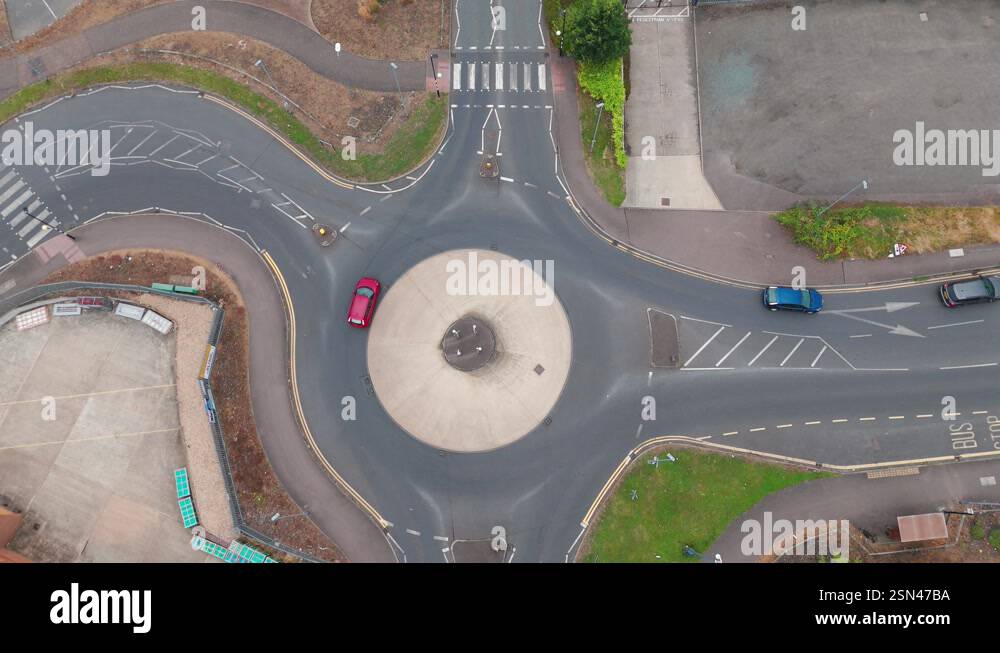 An aerial view of a roundabout with cars navigating the lanes. The ...