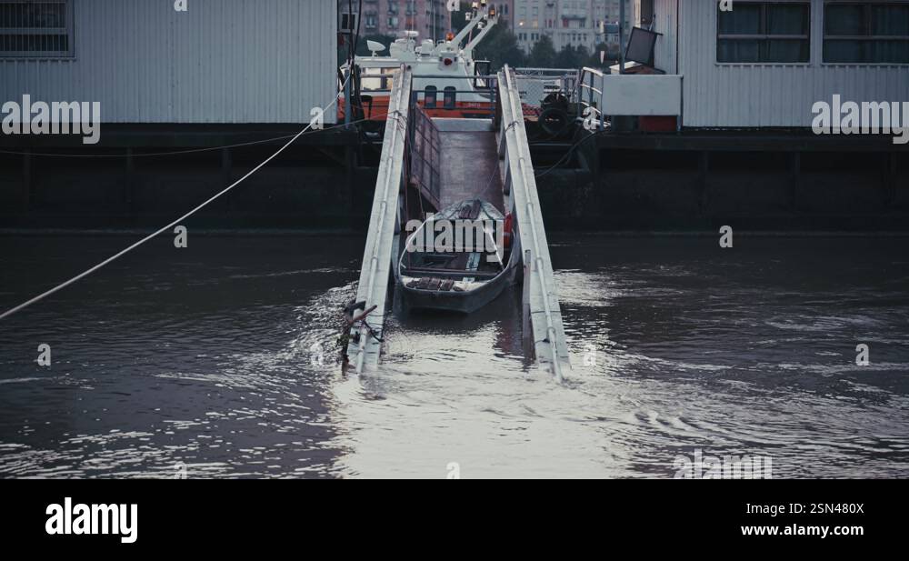 boat is docked on a flooded pier, with water surrounding its ramp on ...