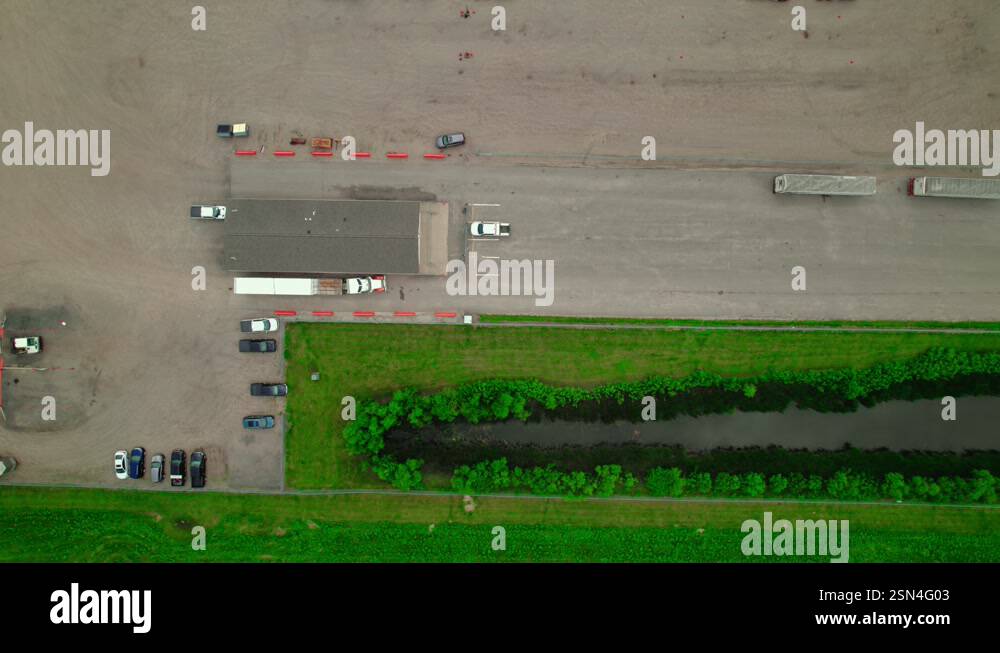 Top-down aerial view of flatbed semi-trucks at the check-in guard ...