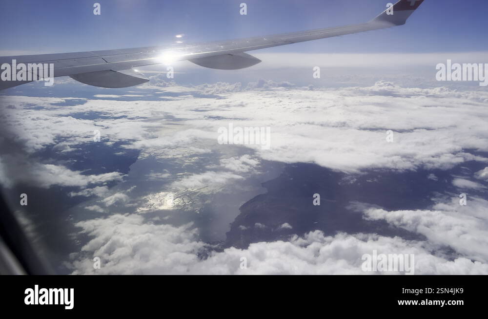 This shot shows the clouds and the landscape from above, filmed out of ...