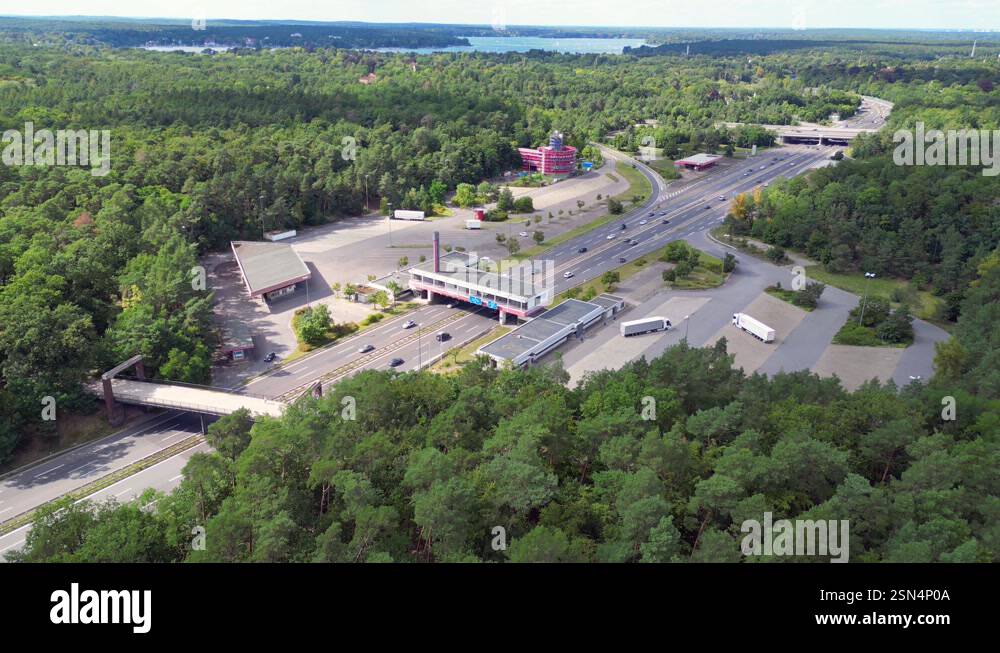 Cars driving on a freeway interchange surrounded by forest leading to a ...