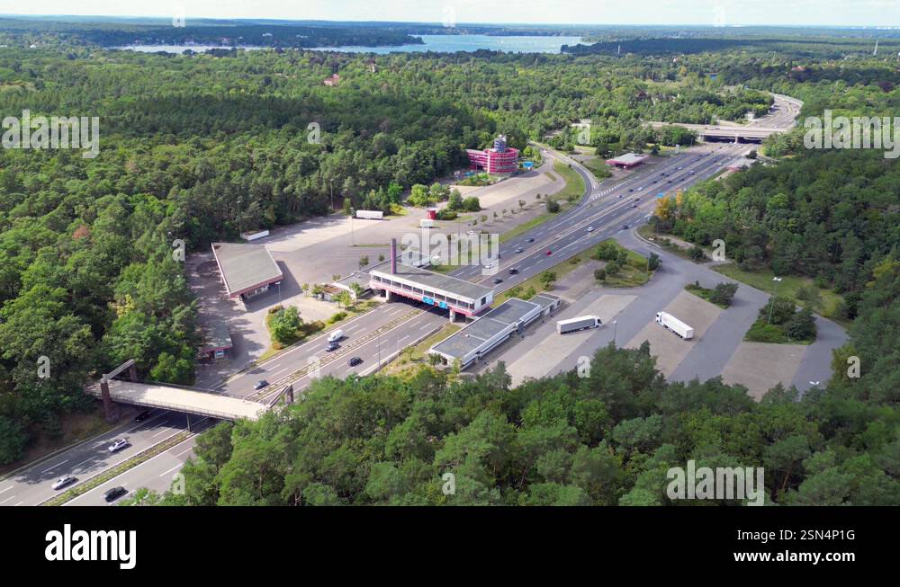 Cars driving on a freeway interchange surrounded by forest leading to a ...