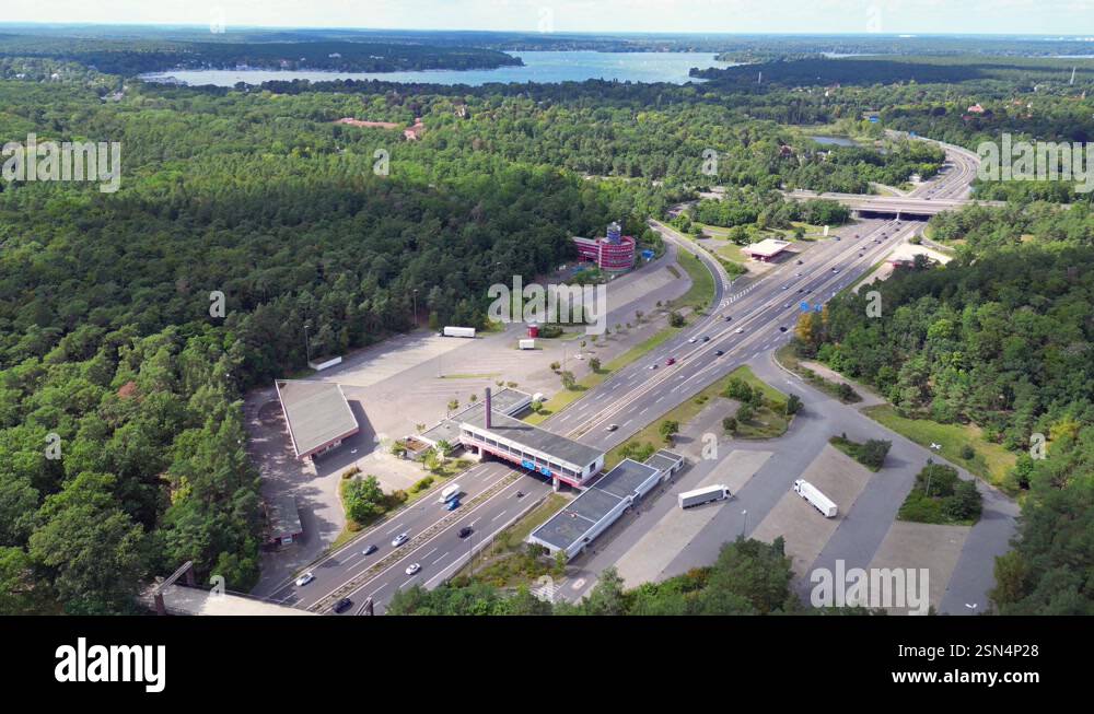 Cars driving on a freeway interchange surrounded by forest leading to a ...