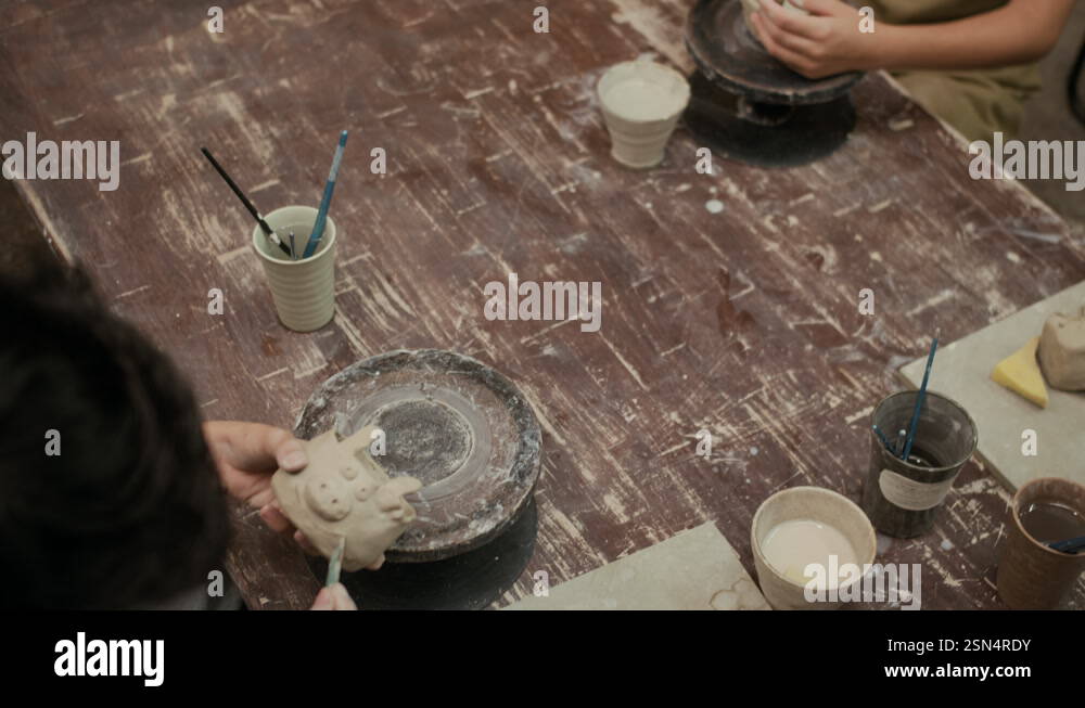 Two Children Modeling Clay Mugs with Decorations at Pottery Class Stock ...