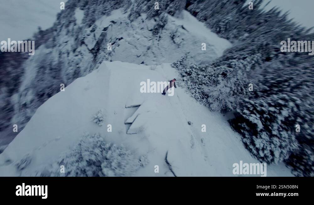 FPV drone captures sweeping aerial views of snow-covered cliffs and ...