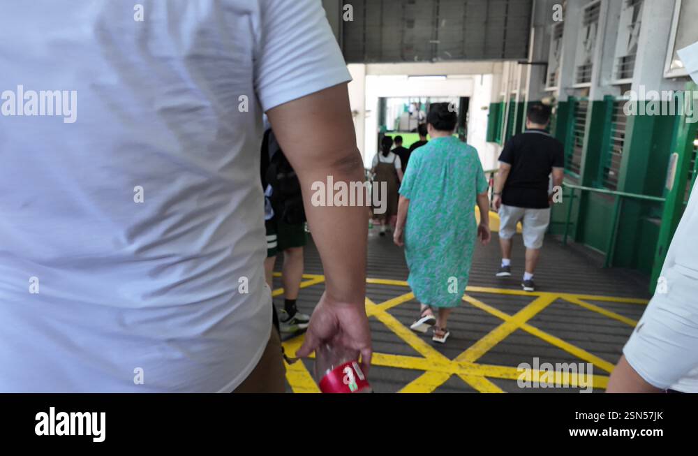 A group of people walk across a yellow marked walkway toward a closed ...