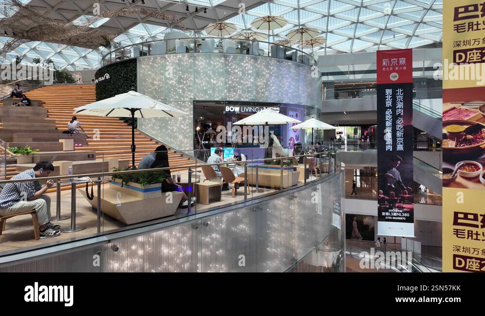 Interior of a modern shopping mall with a glass ceiling, wooden stairs ...