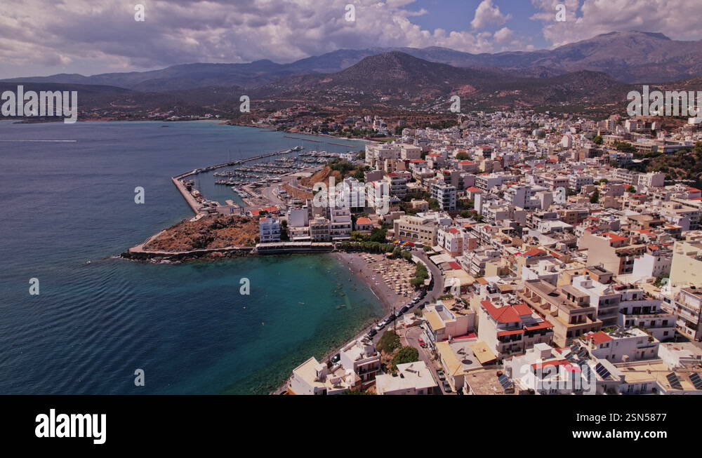Scenic aerial view of coastal town with marina in Crete during daylight ...
