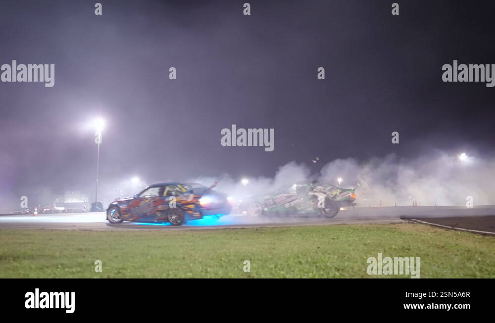 Wide shot of two cars side by side drift in roundabout at night 4K ...
