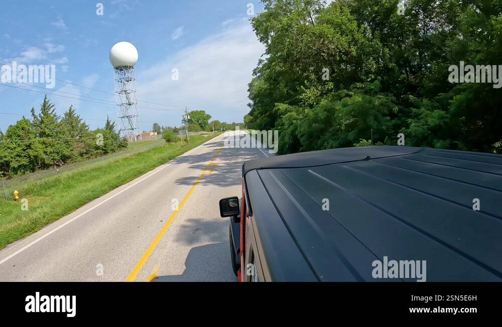 POV from vehicle roof - driving on a country road past a doppler radar ...