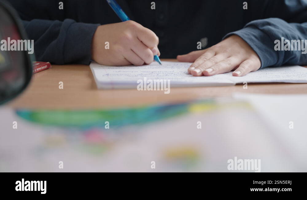 Close-up footage of children writing and reading in a classroom ...