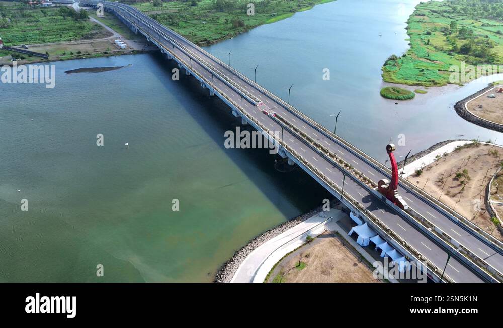 Aerial view of asphalt road over a bridge that crosses a large river ...