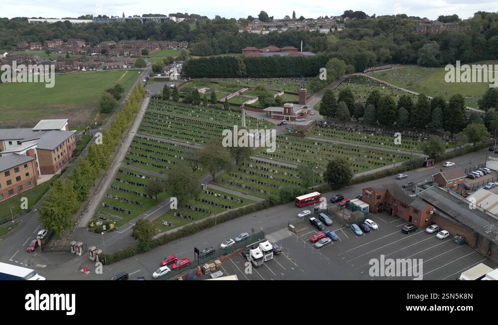 Drone aerial view of a cemetery and graveyard in England with a passing ...