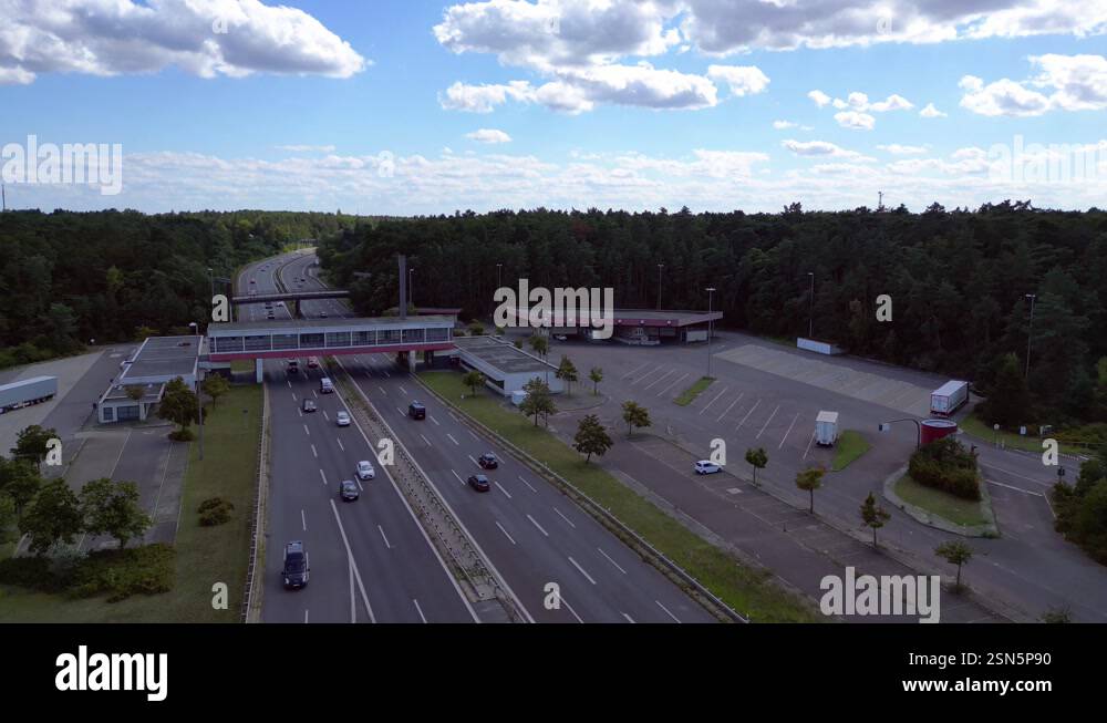 highway rest stop with cars driving on a multi lane highway. overflight ...