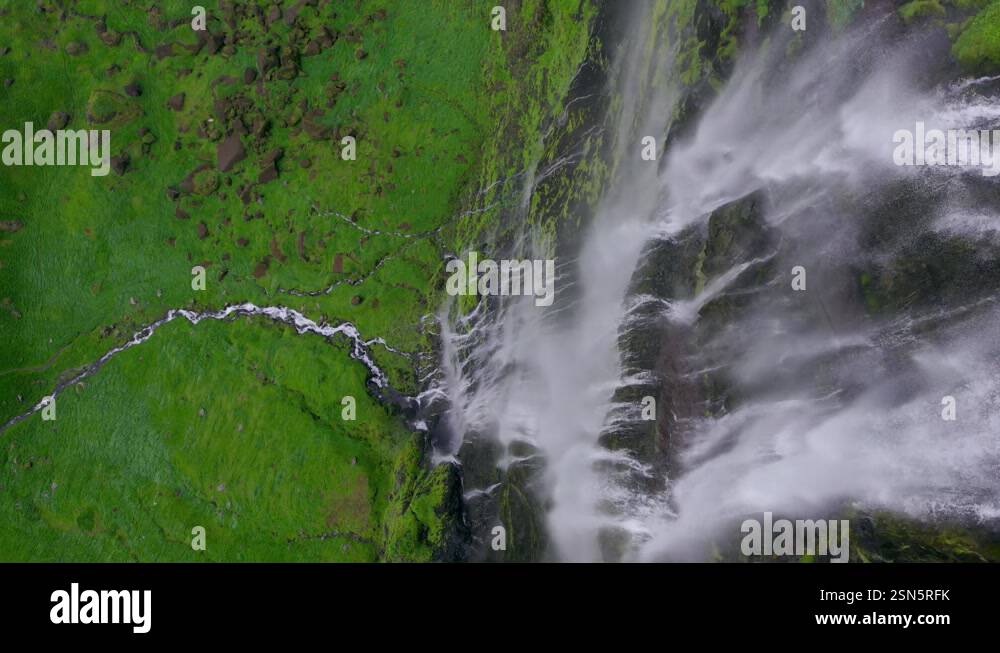 Overhead drone captures stunning waterfall cascading down majestic ...