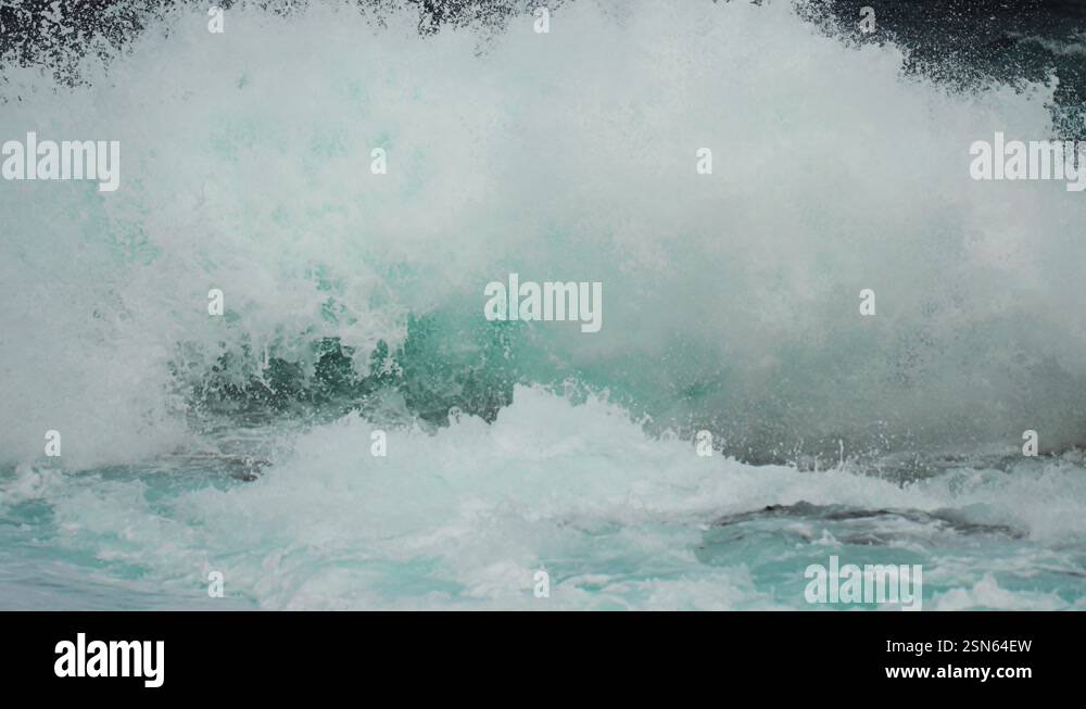 A massive turquoise wave crashes with force near the iconic Atlantic ...