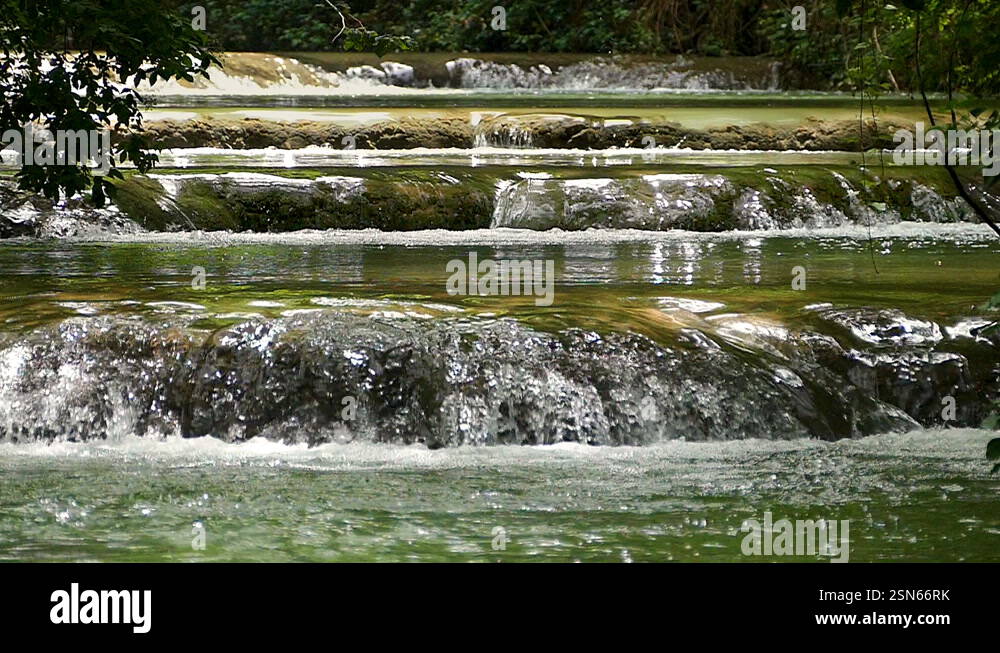 Small consecutive waterfalls that flow in an idyllic place. Slow Motion ...