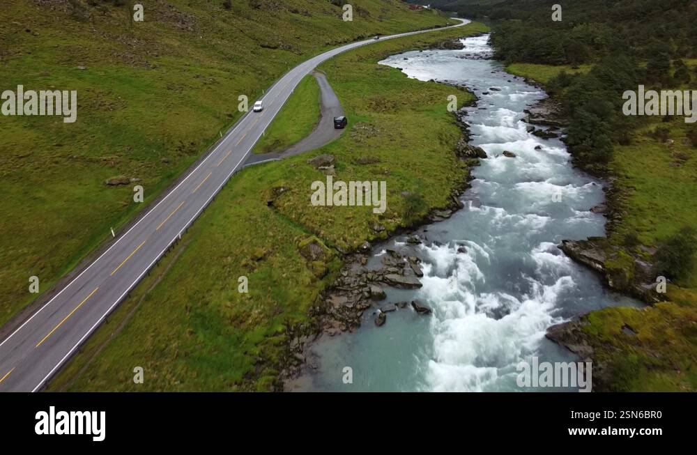 Car driving down a long road next to a wild river in Norway Stock Video ...