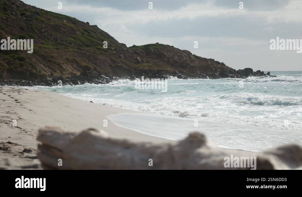 Rhythmic waves gently crash onto the shore, creating a soothing ...