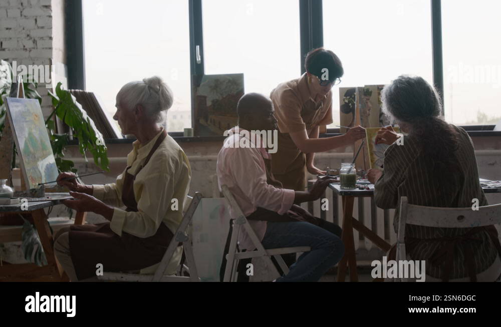 Female Teacher Helping Senior Man Finish His Picture in Art Studio ...