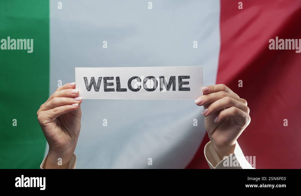 Woman with Welcome lettering title text cardboard on italian flag ...