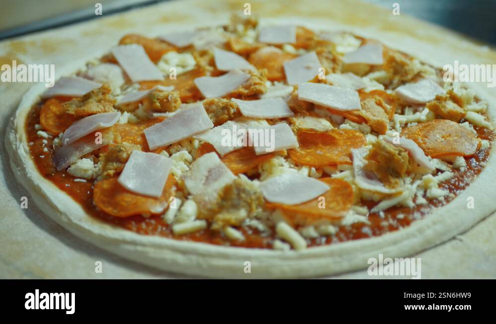 Adding toppings ham meat pizza by chef in restaurant takeaway store ...